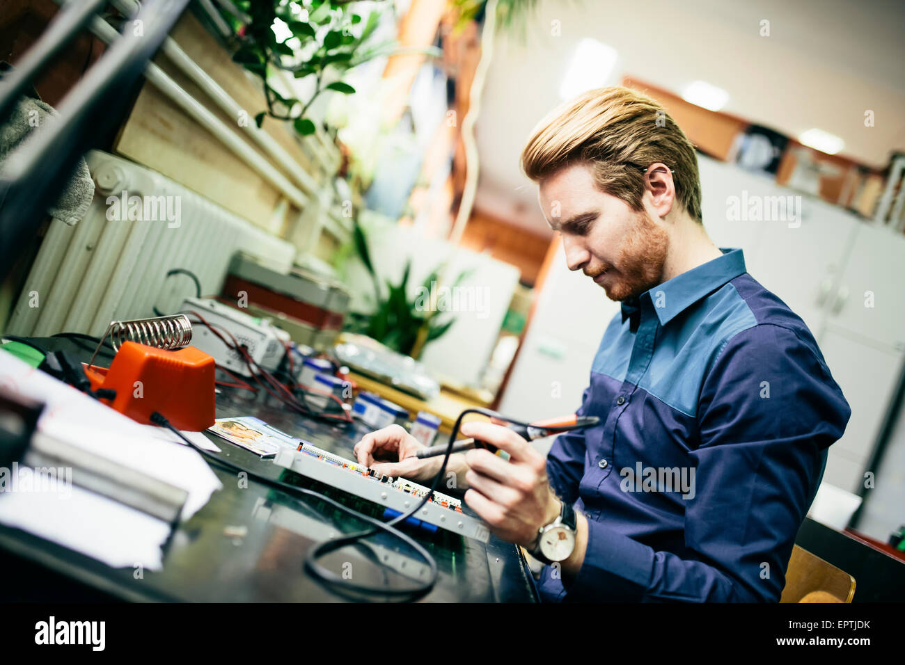 Young man in electronics workshop Stock Photo - Alamy