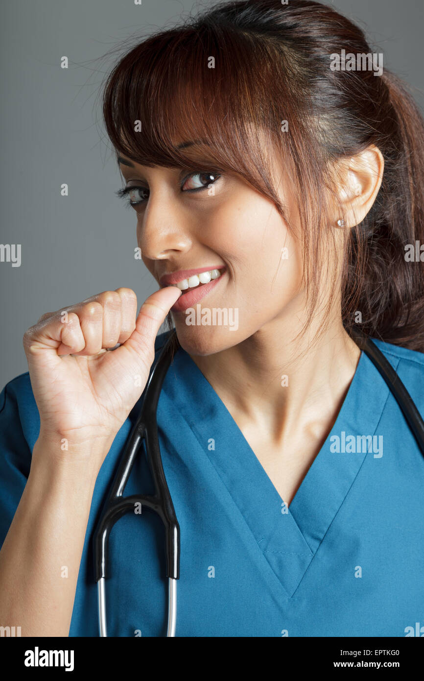 Attractive Indian doctor woman posing in a studio in front of a ...