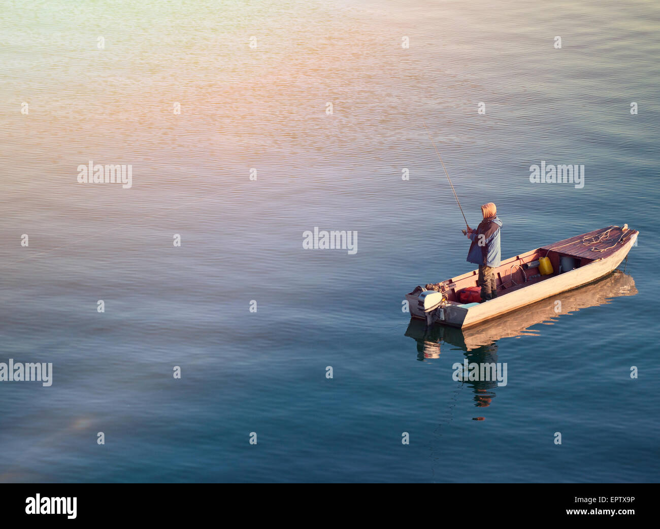 Fisherman in boat fishing Stock Photo - Alamy