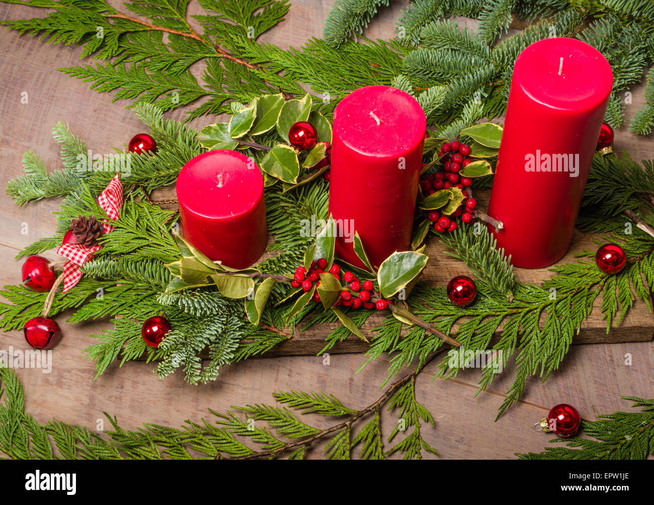 Three red candles in a Christmas decorative centerpiece Stock Photo - Alamy