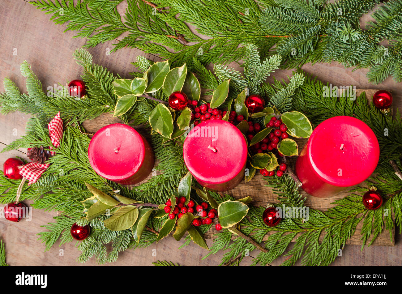 Three red candles in a Christmas decorative centerpiece overhead view ...