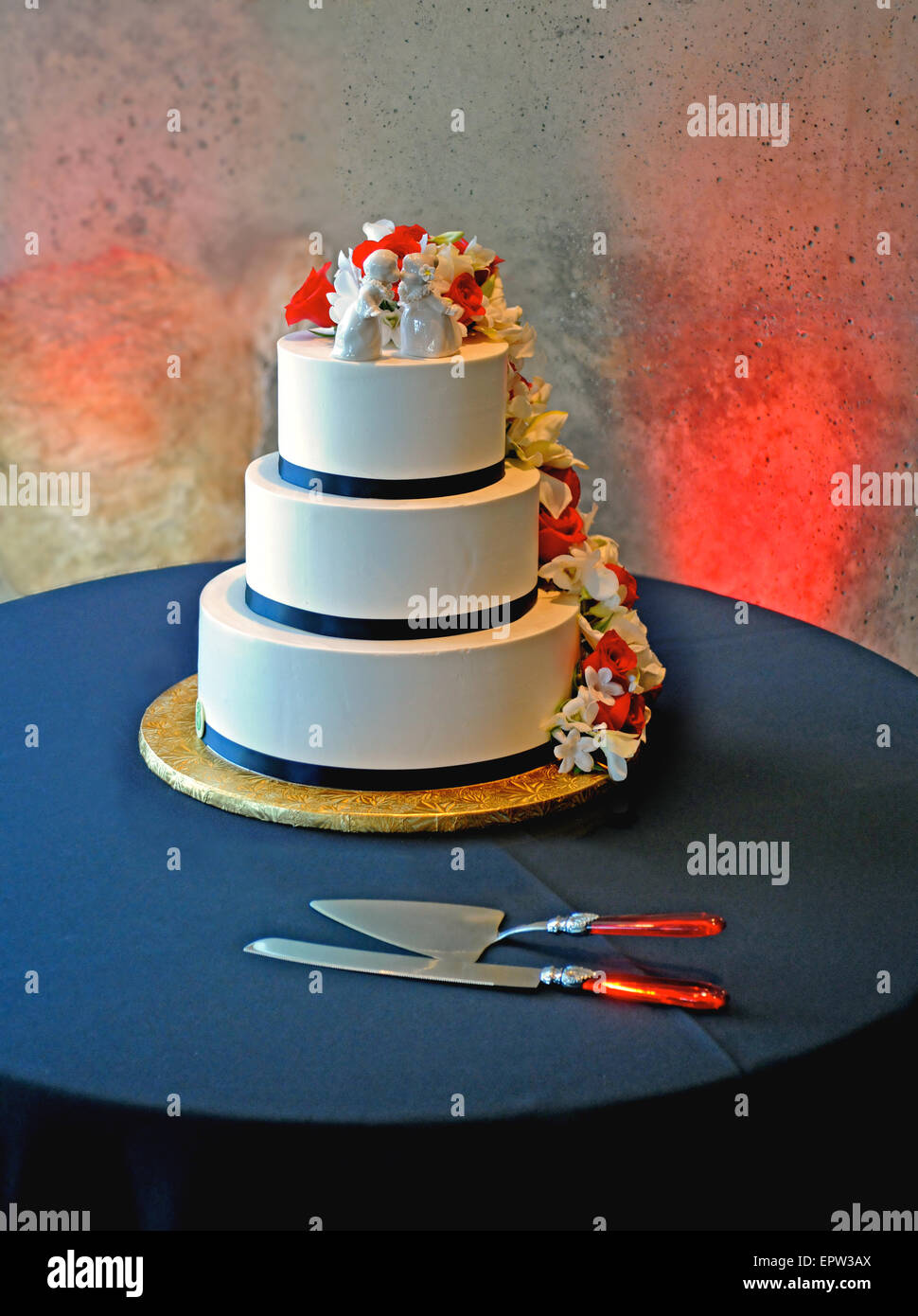 Kissing, white cherubs top a white wedding cake decorated with red ...