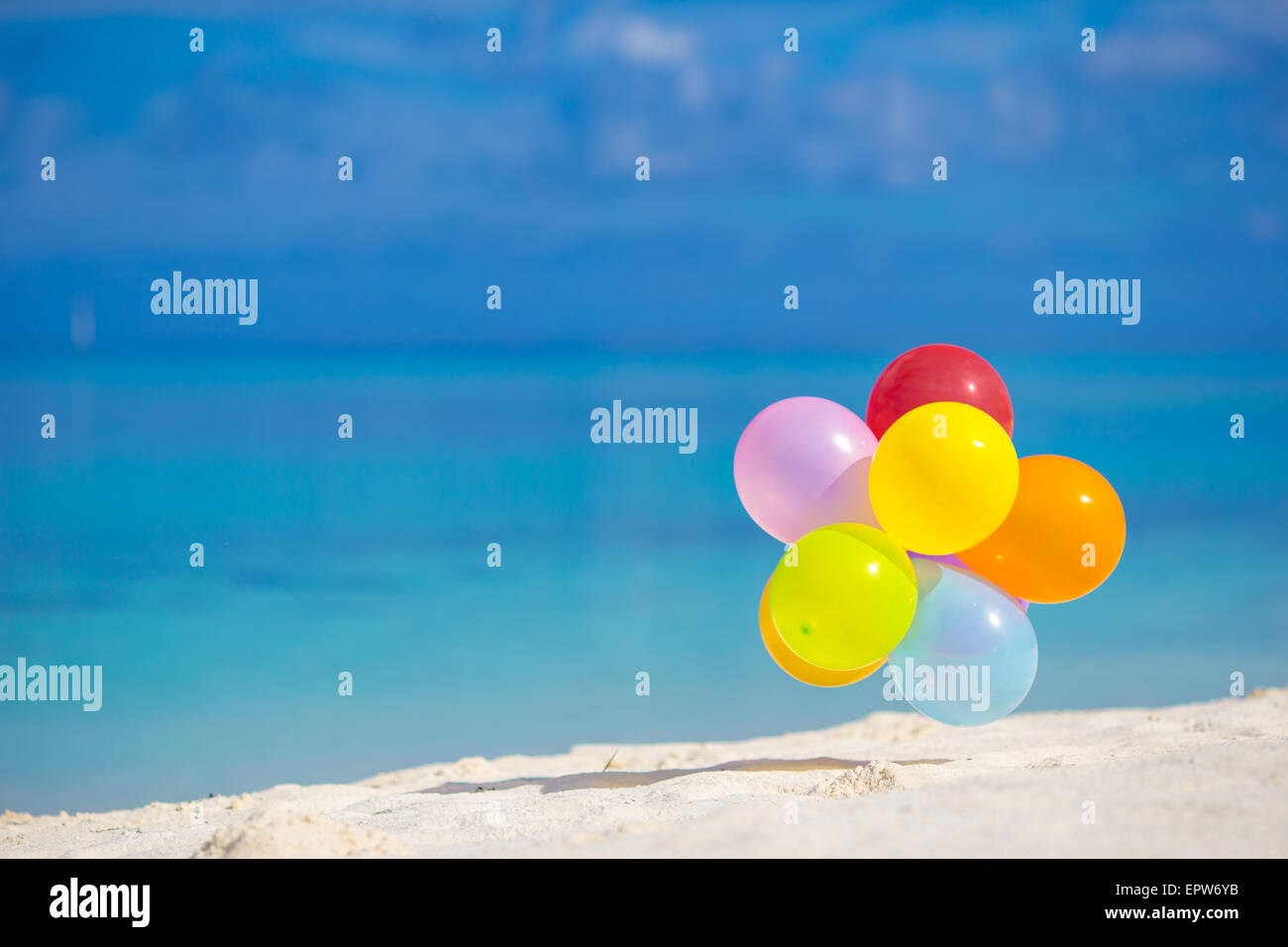 Multicolored balloons on white tropical beach Stock Photo - Alamy