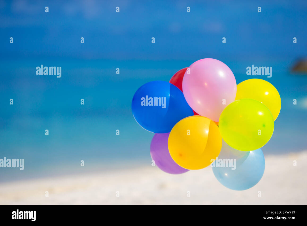 Multicolored balloons on white tropical beach Stock Photo - Alamy
