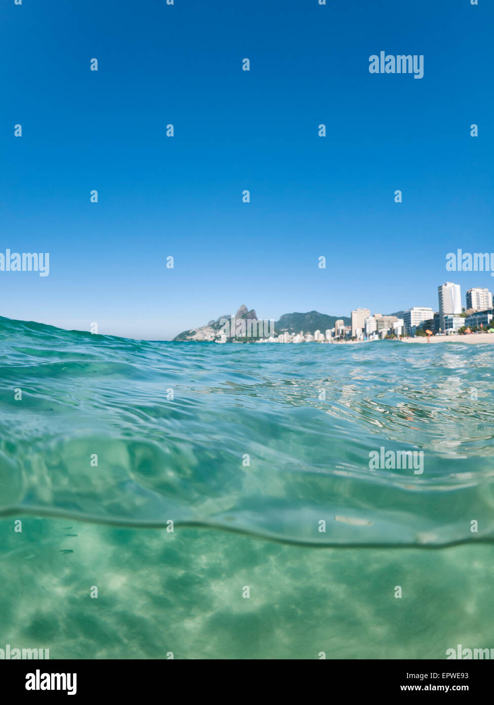 Over-under underwater view of clear green tropical waters off the shore ...