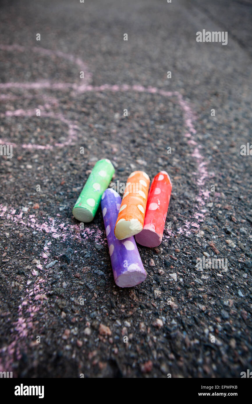 Colorful street chalk on asphalt with a hopscotch drawn to the ground ...