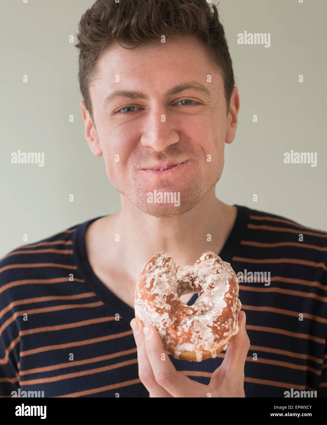 Young man eating donut hi-res stock photography and images - Alamy