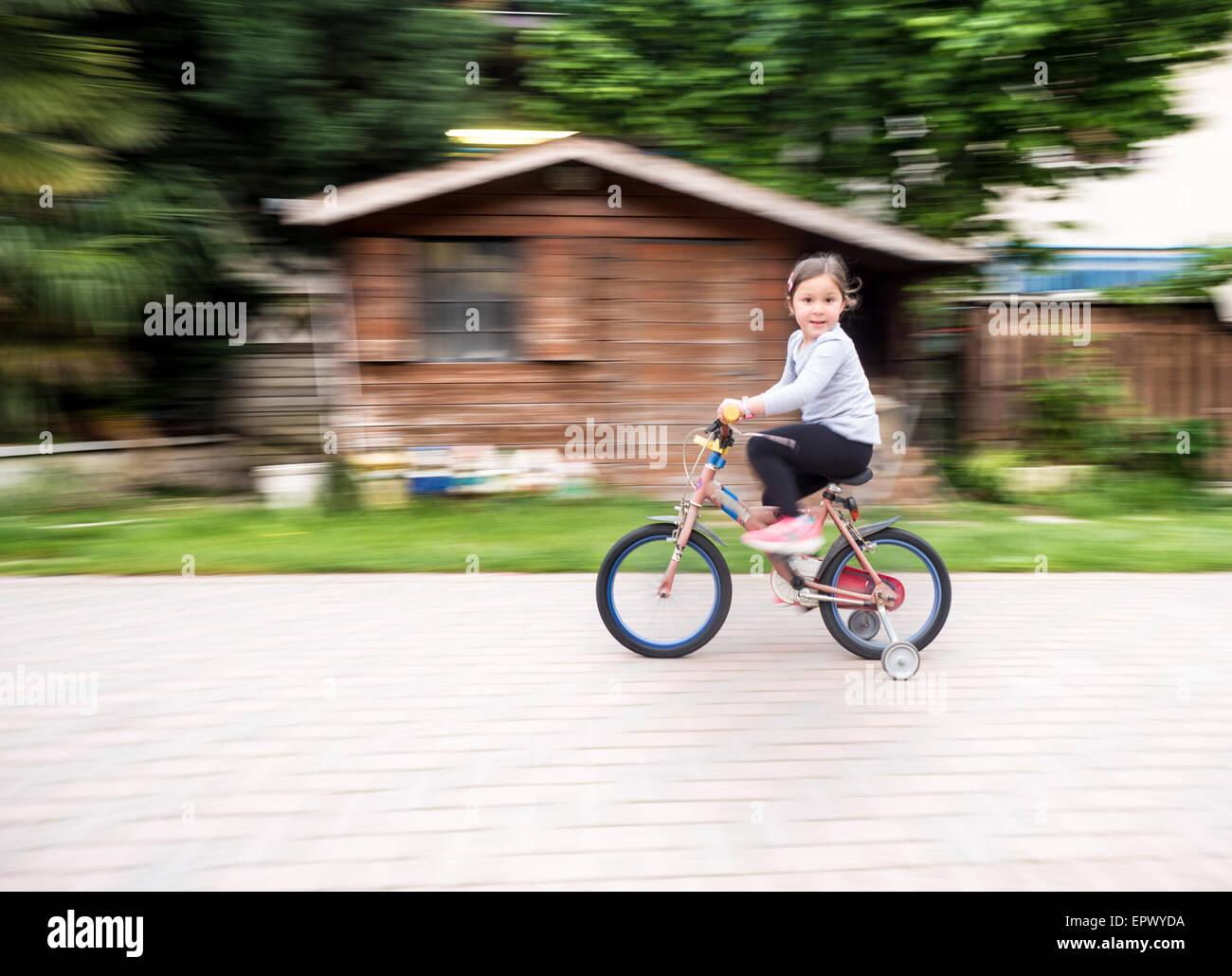 little girl ride fast on bike with casters Stock Photo - Alamy