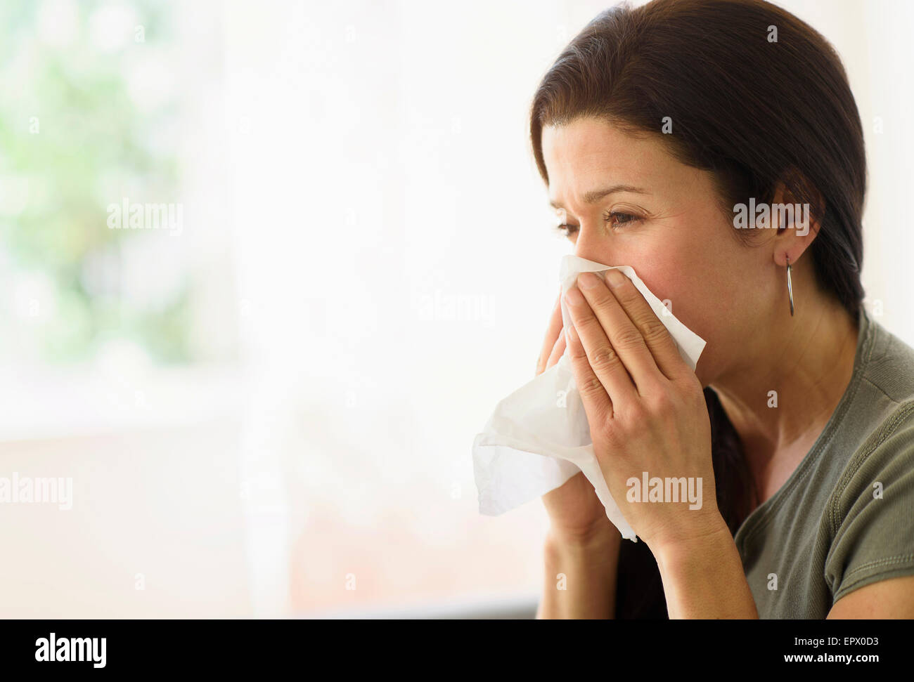 Woman blowing her nose Stock Photo - Alamy