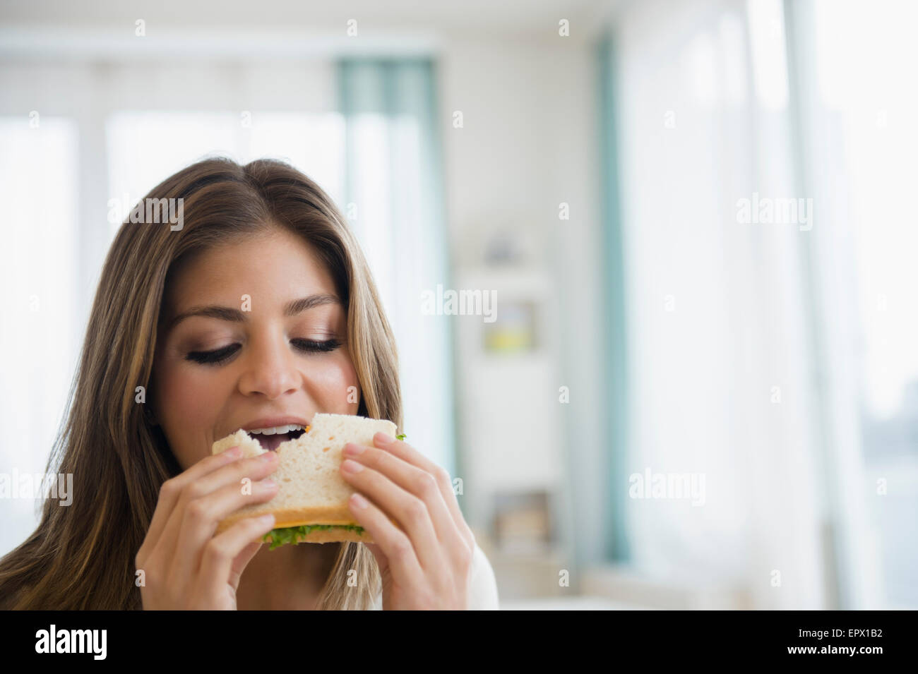 Young woman eating sandwich Stock Photo - Alamy