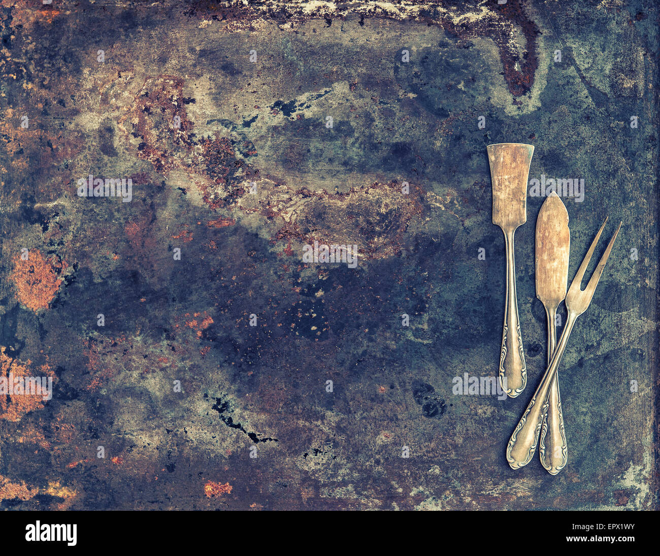 Antique silver cutlery on rustic textured metal background. Old ...