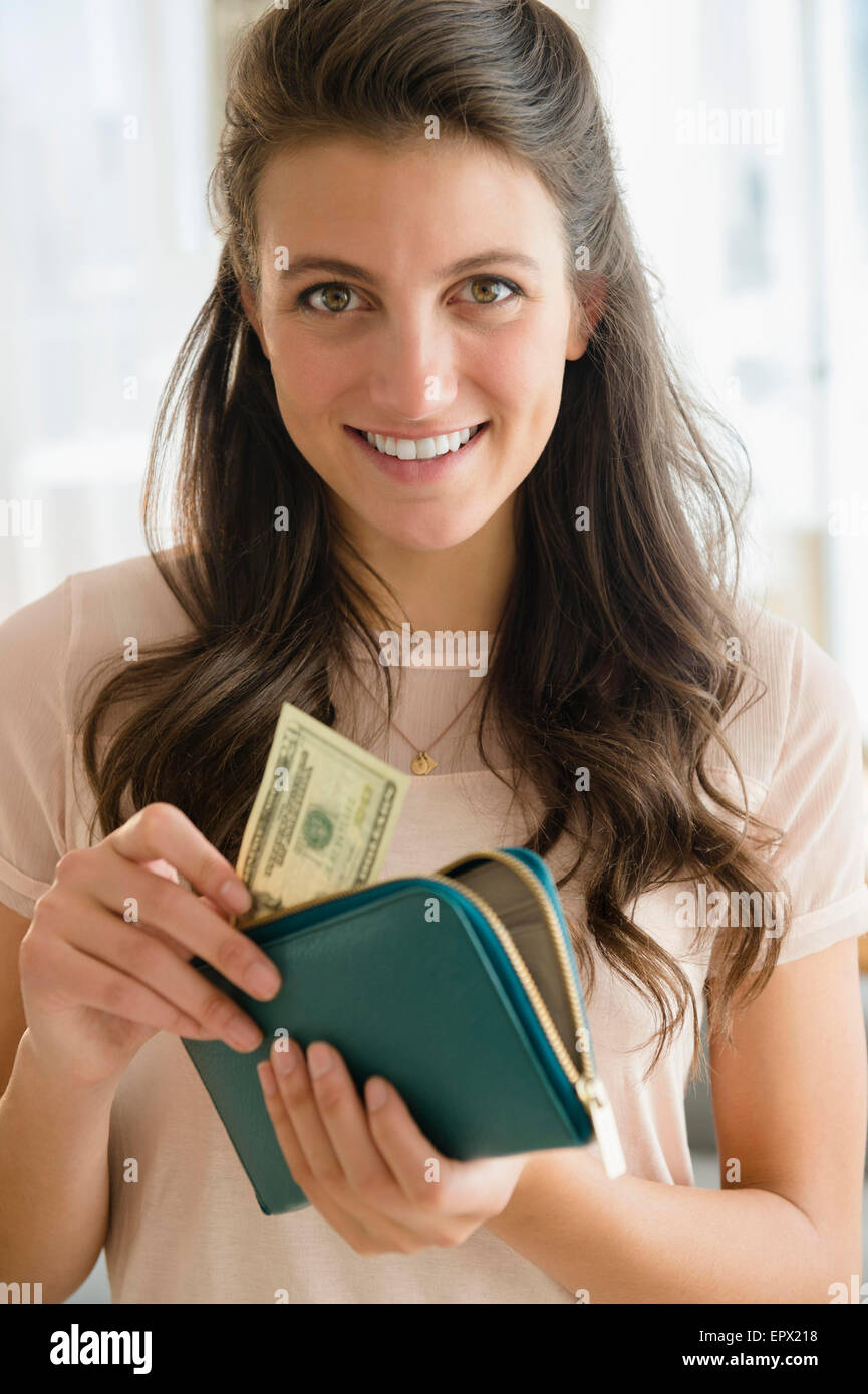Woman putting banknote to wallet Stock Photo - Alamy