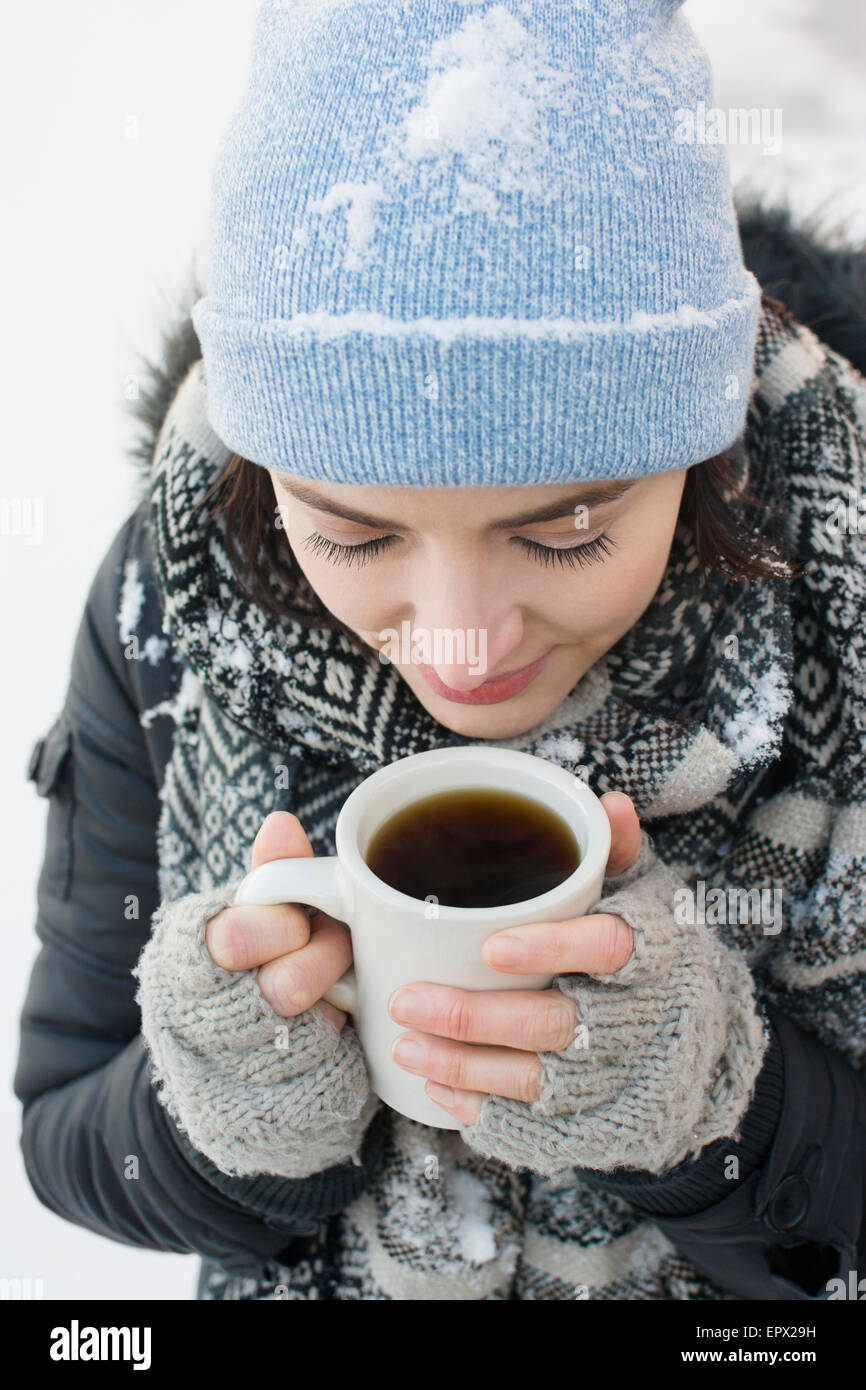 Woman with coffee mug in snow Stock Photo - Alamy