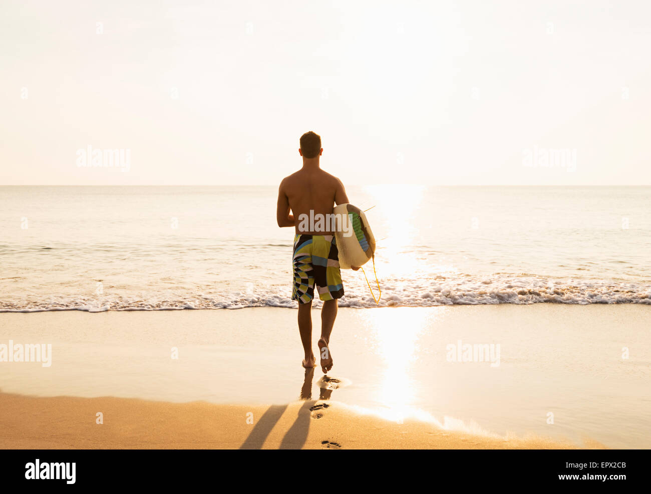 USA, Florida, West Palm Beach, Rear view of surfer walking towards sea ...