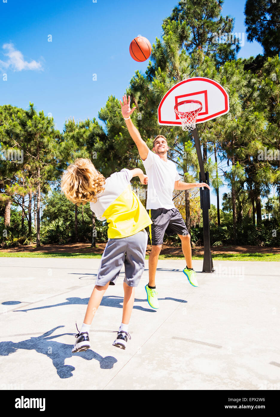Kids Playing Basketball Outside In Driveway