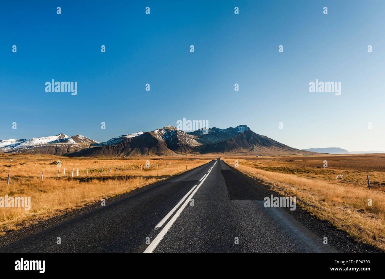 Road in autumn country with mountains on horizon and blue sky Stock ...