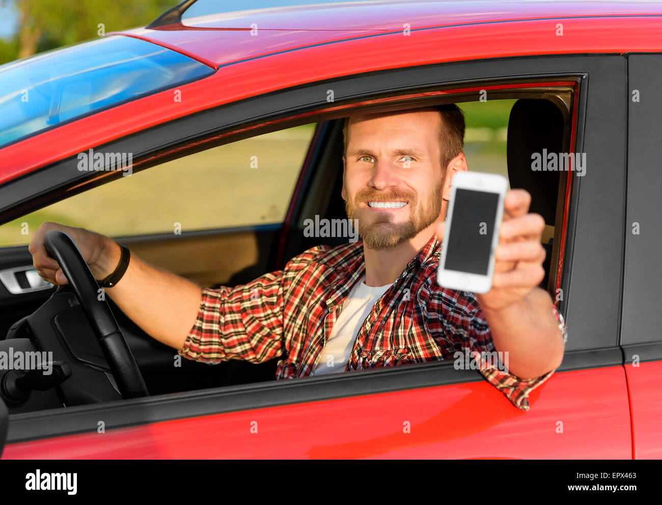 Man in car driving showing smart phone Stock Photo - Alamy