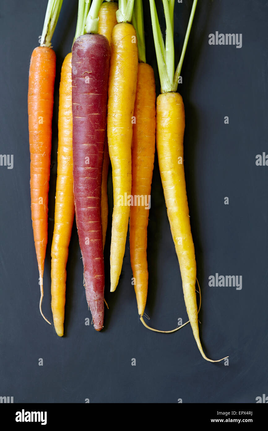 Stack of carrots on black background Stock Photo - Alamy