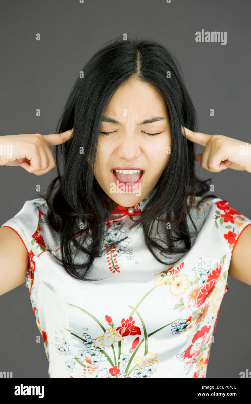 Asian young woman shouting with hands in ear Stock Photo - Alamy