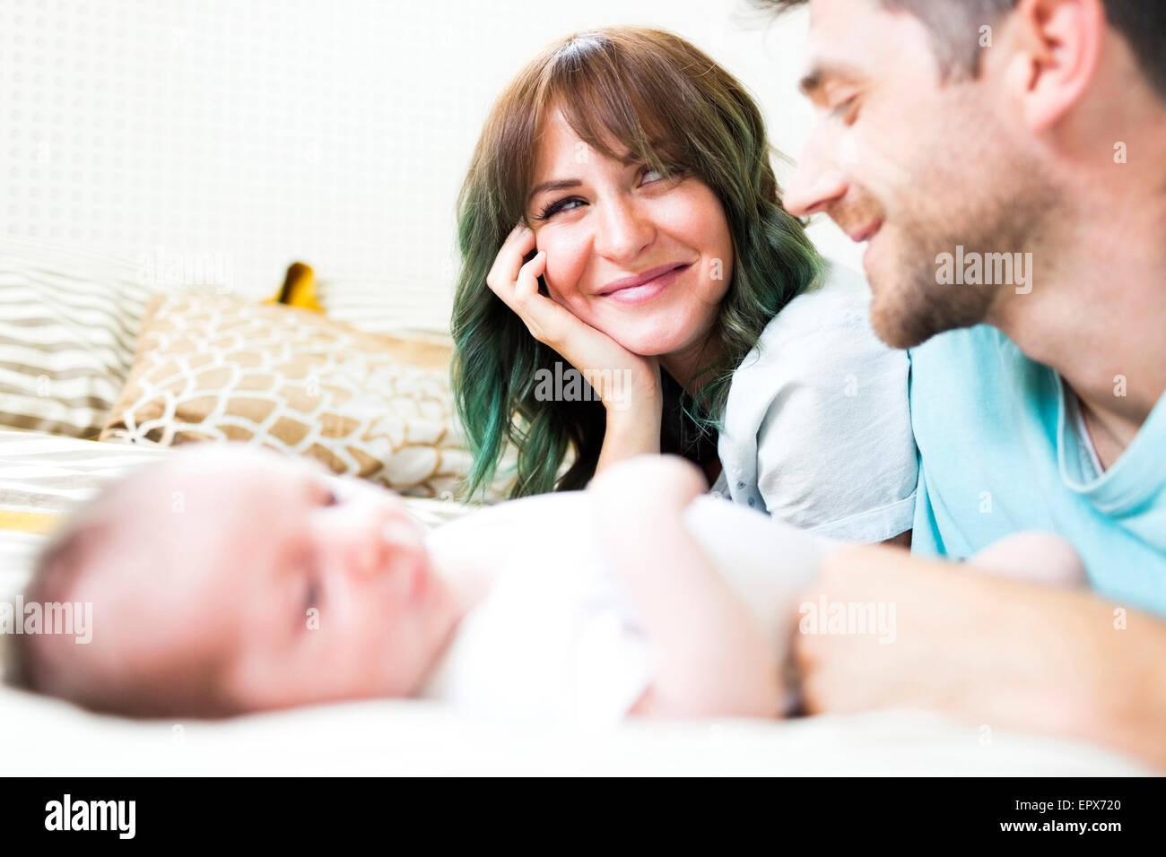Happy parents with baby boy (6-11 months) on bed Stock Photo - Alamy