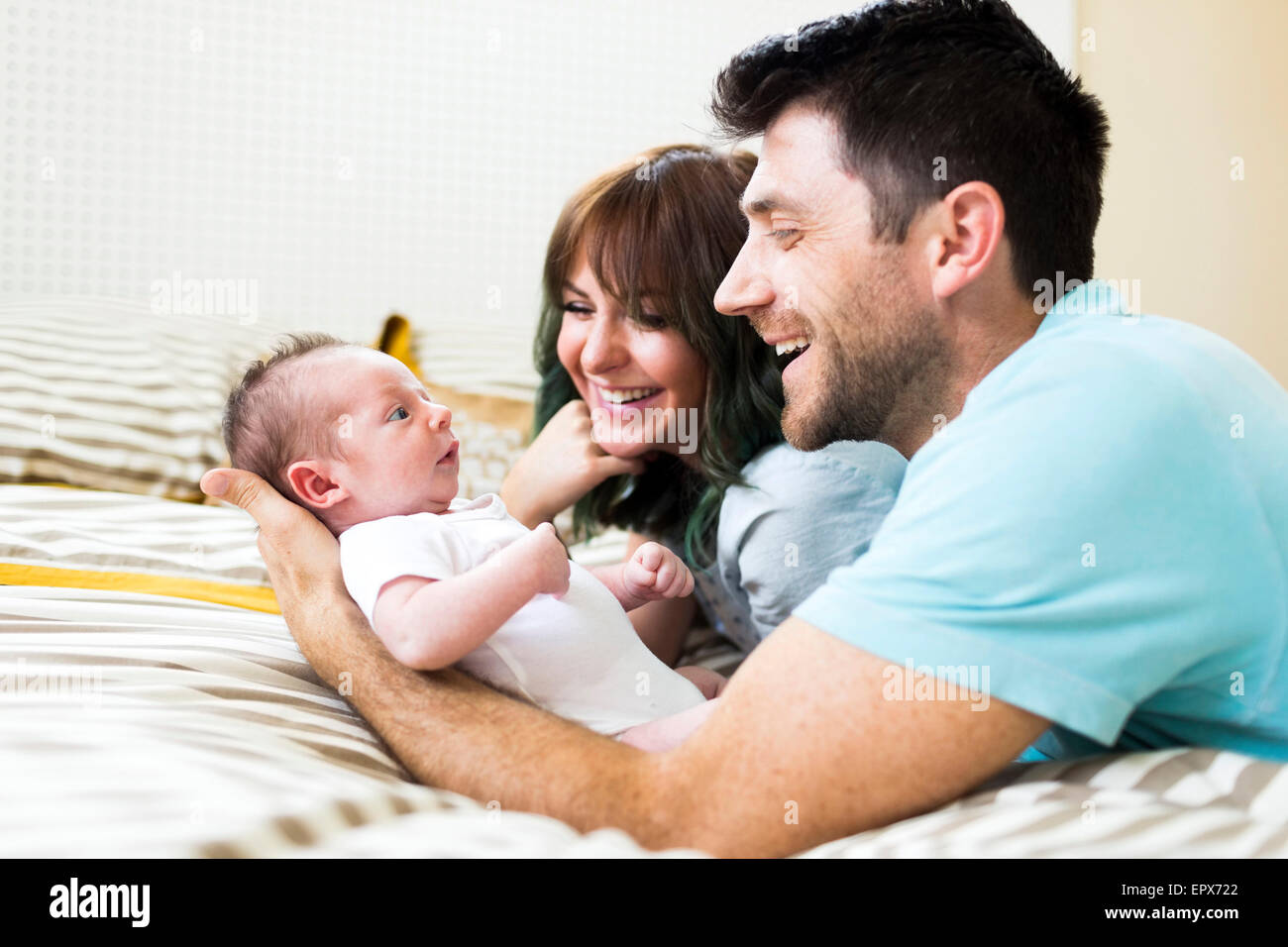 Happy parents playing with baby boy (6-11 months) on bed Stock Photo ...
