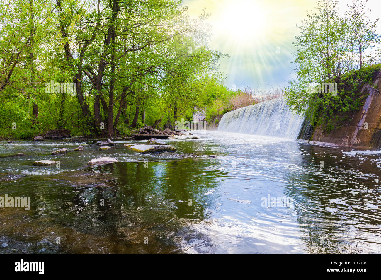 spring landscape waterfall flows into the river Stock Photo - Alamy