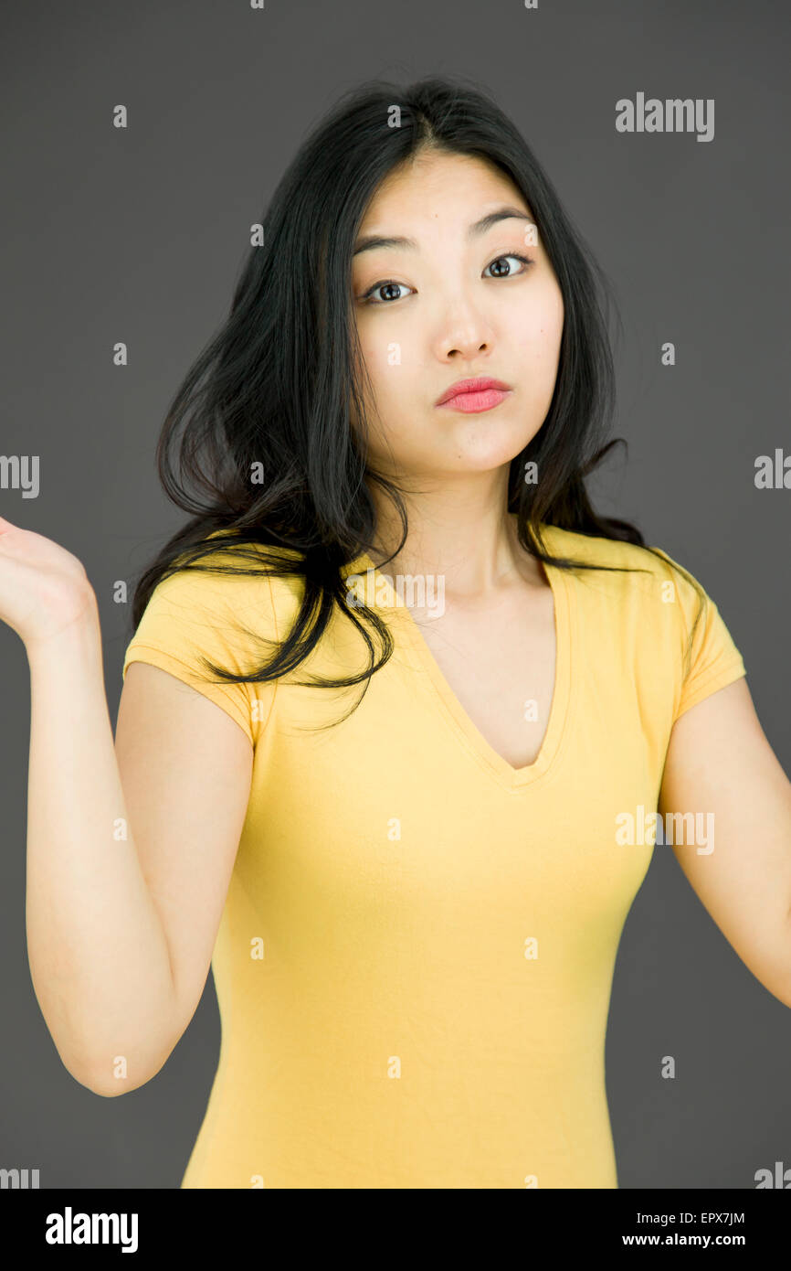 Young Asian woman shrugging Stock Photo - Alamy