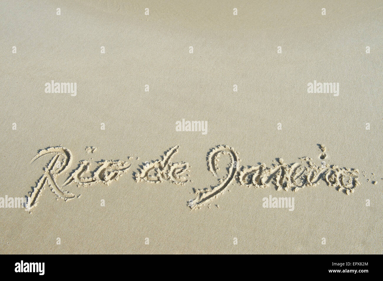 Rio de Janeiro message handwritten on smooth sand beach with clean copy ...