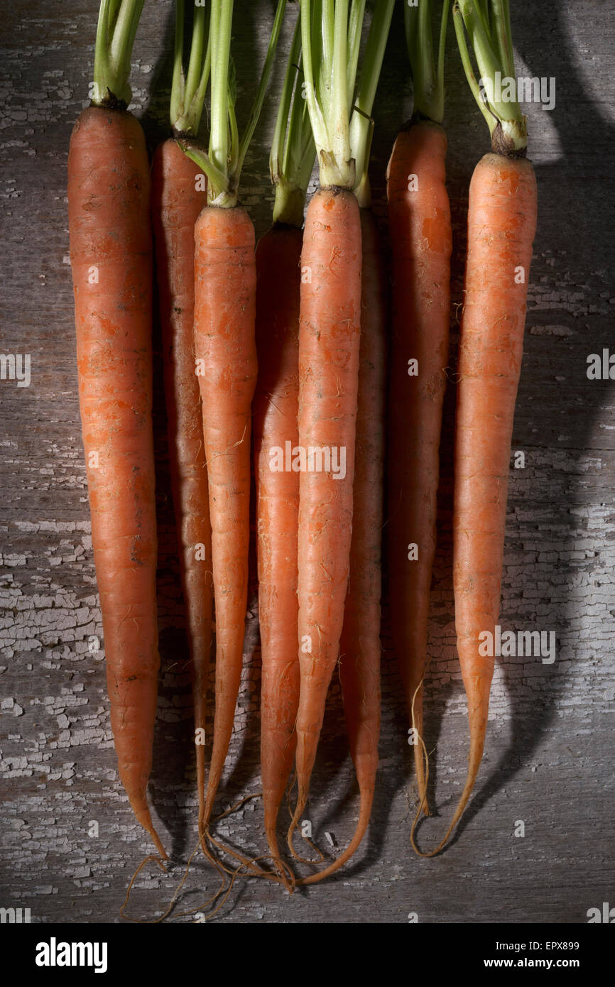 Whole carrots on weathered wood table Stock Photo - Alamy