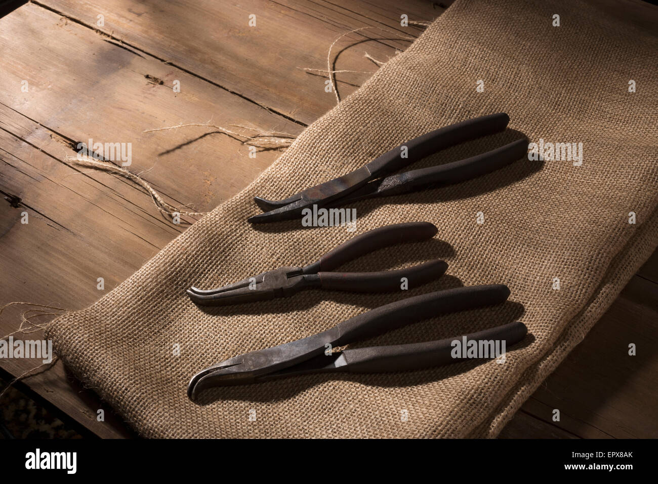 Silversmith's tools arranged on linen fabric, wooden table Stock Photo ...