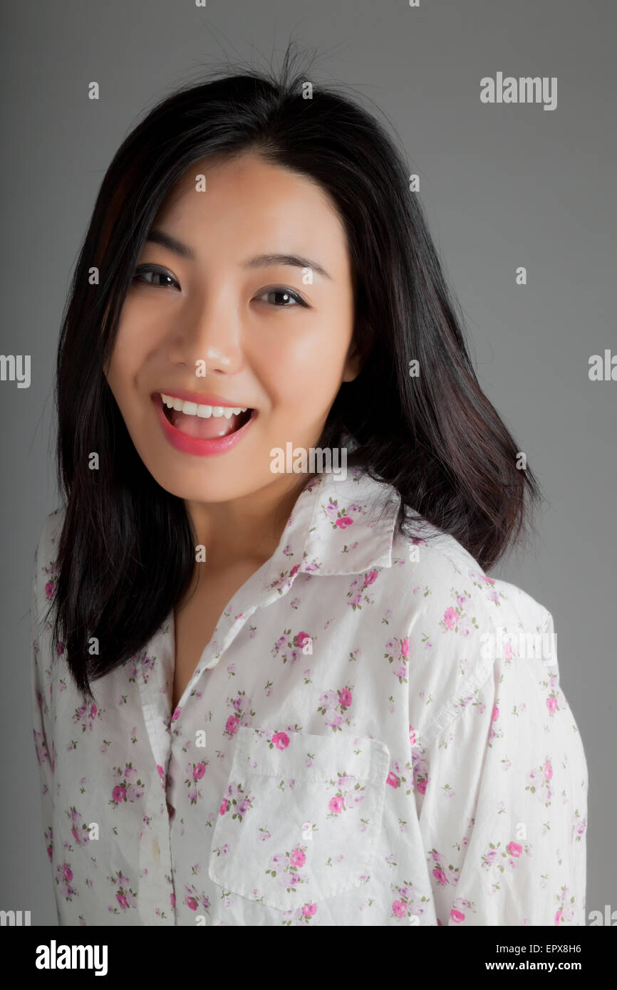Attractive asian girl in her twenties isolated on a plein background ...