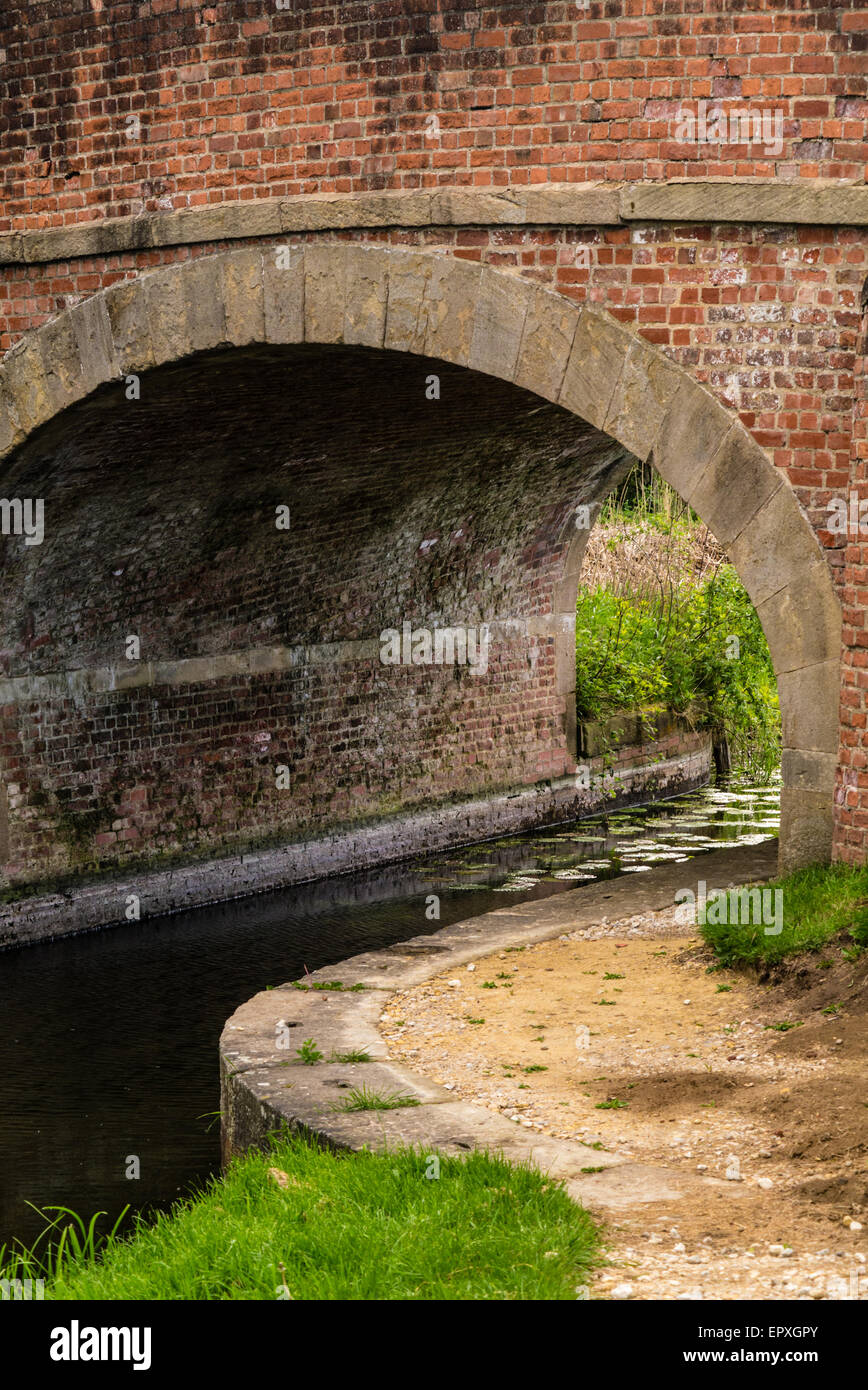 Road bridge over a canal with footpath under bridge. View under bridge ...