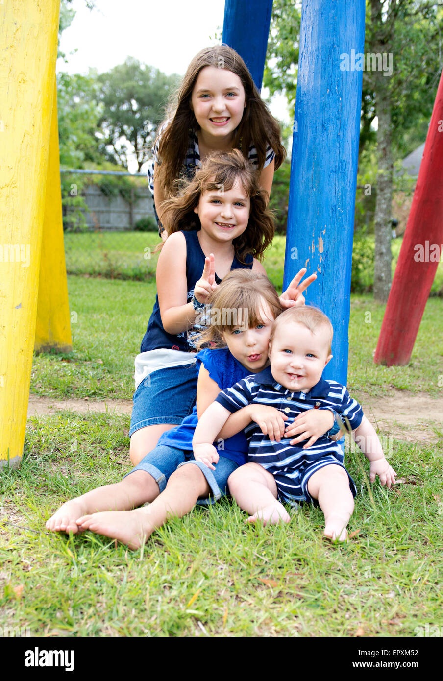 Children pose for fun family portrait at an outdoor park playground ...