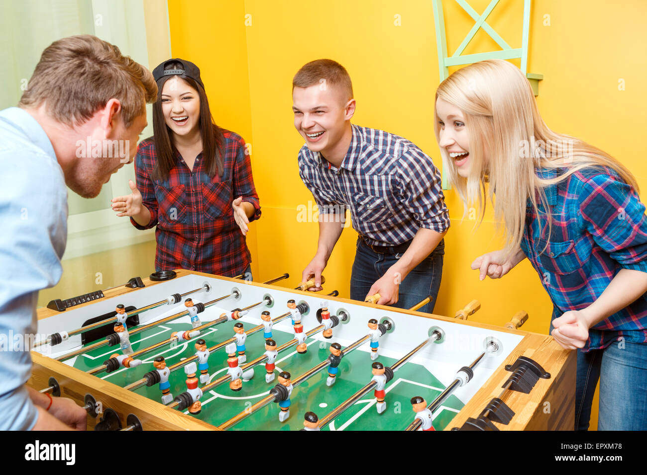 Happy friends playing table hockey Stock Photo - Alamy