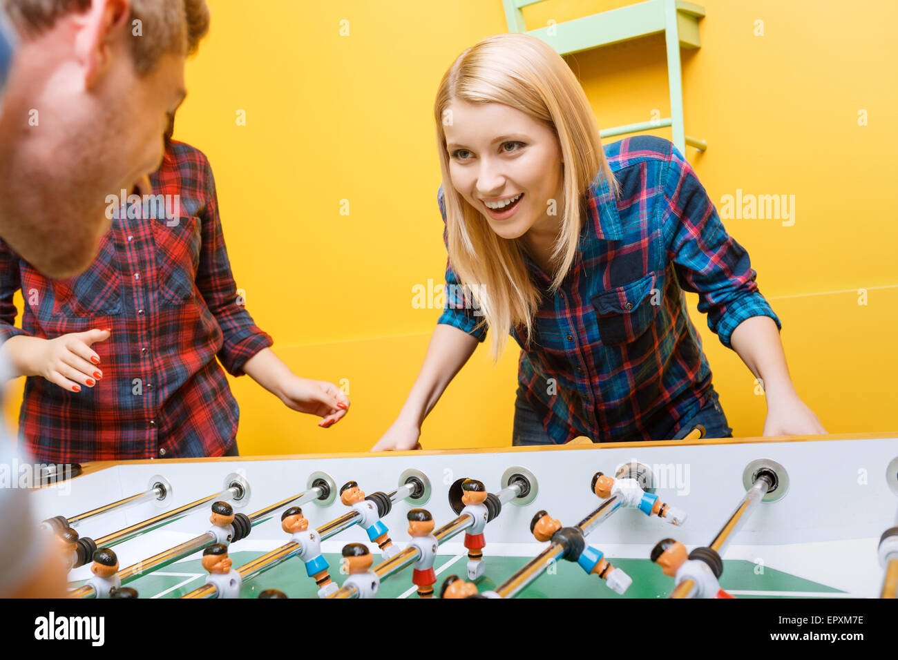 Happy friends playing table hockey Stock Photo - Alamy