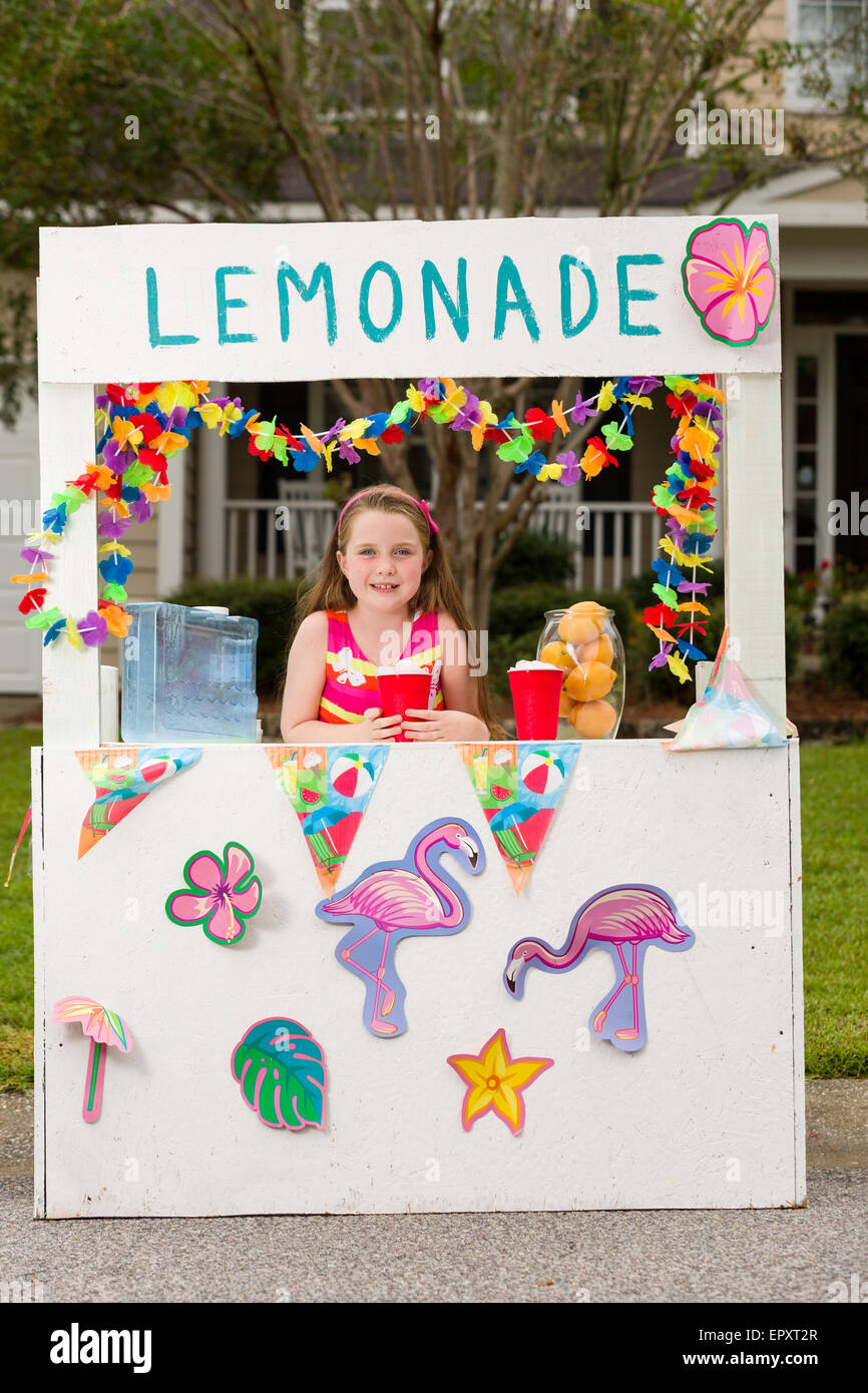 Rachel Mennet, a third-grader, stands behind her lemonade stand to ...
