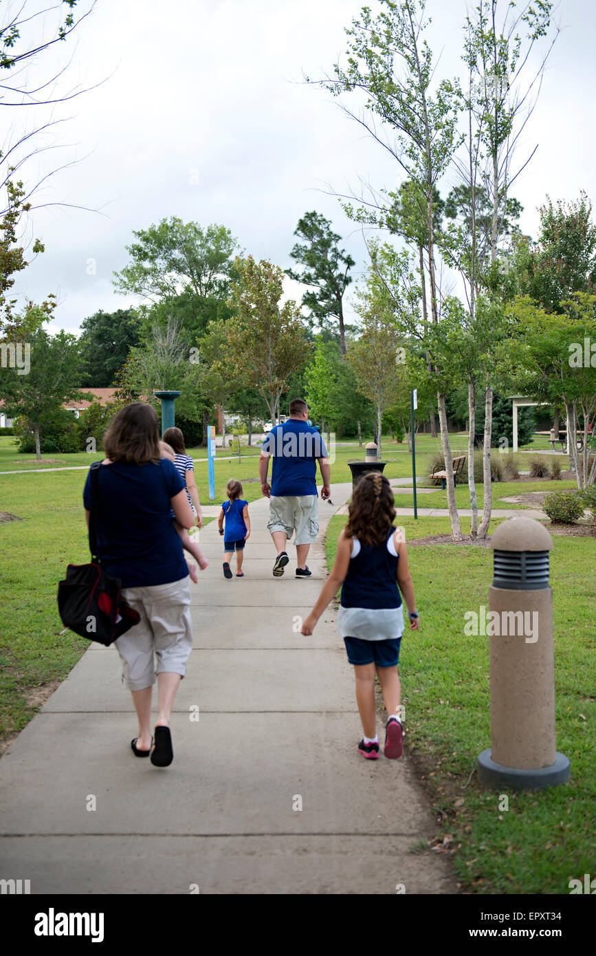 Family walking down a sidewalk in a city park Stock Photo - Alamy