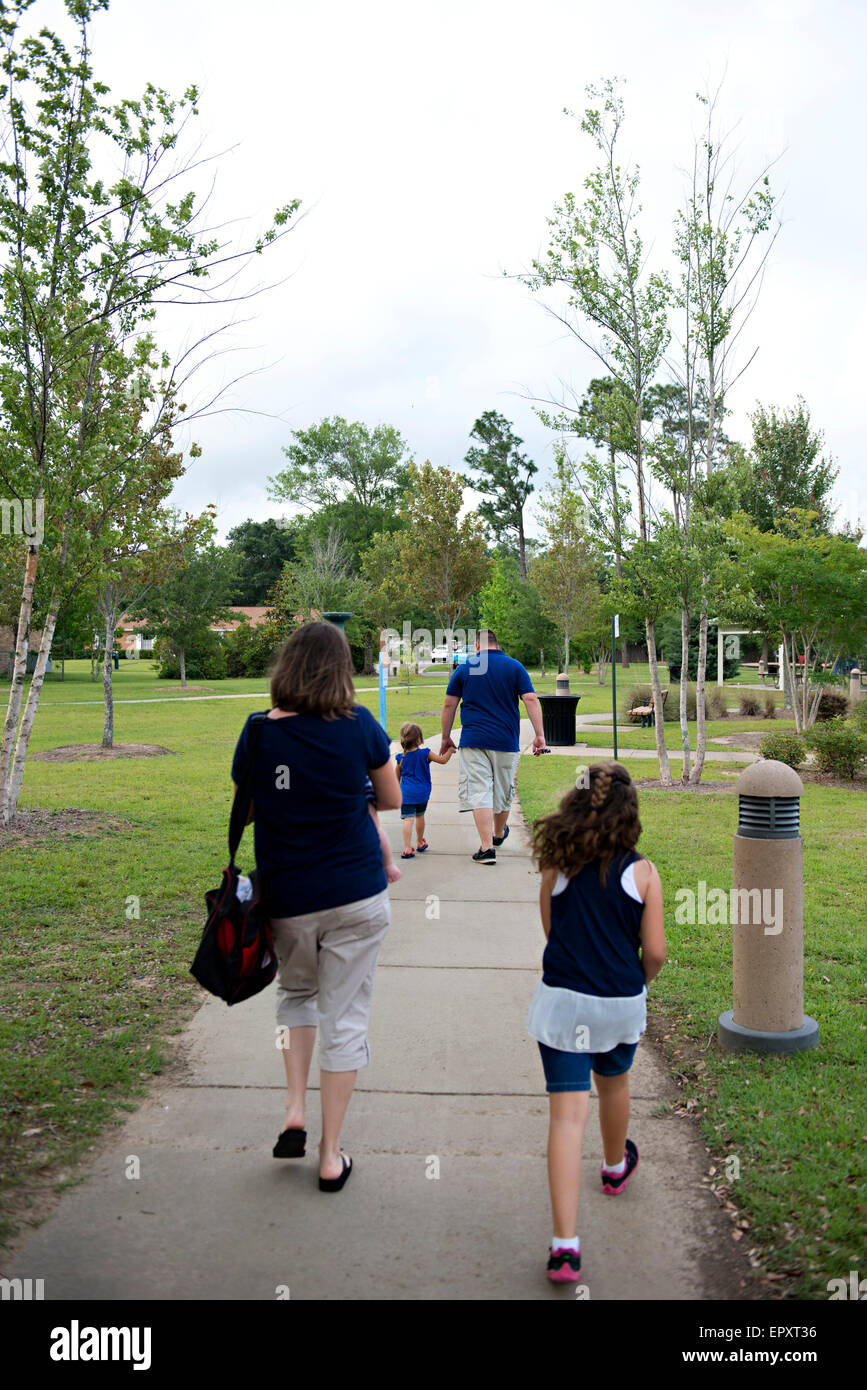 Family walking down a sidewalk in a city park Stock Photo - Alamy