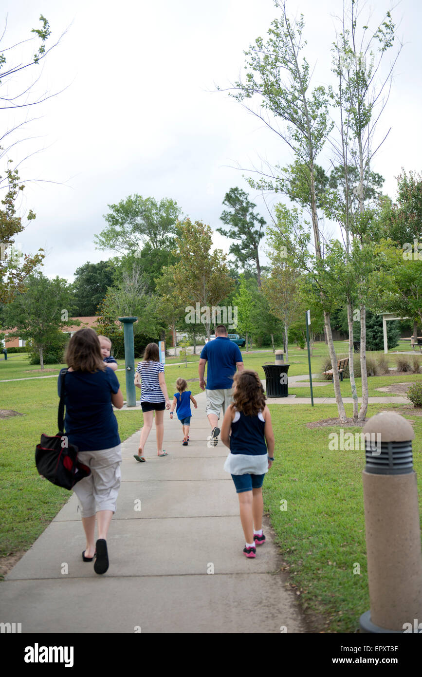 Family walking down a sidewalk in a city park Stock Photo - Alamy