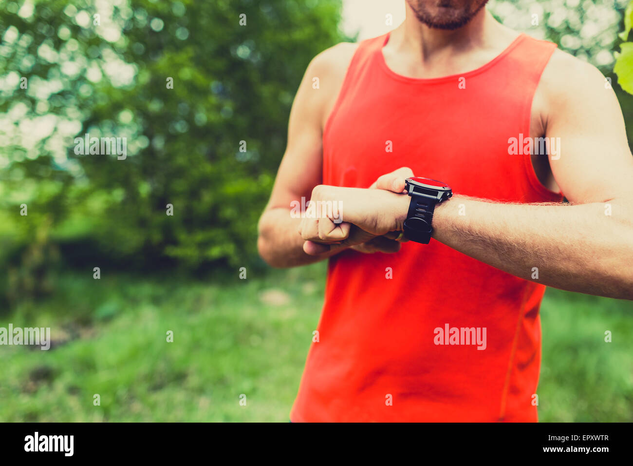 Runner on mountain trail checking looking at sportwatch smart watch ...