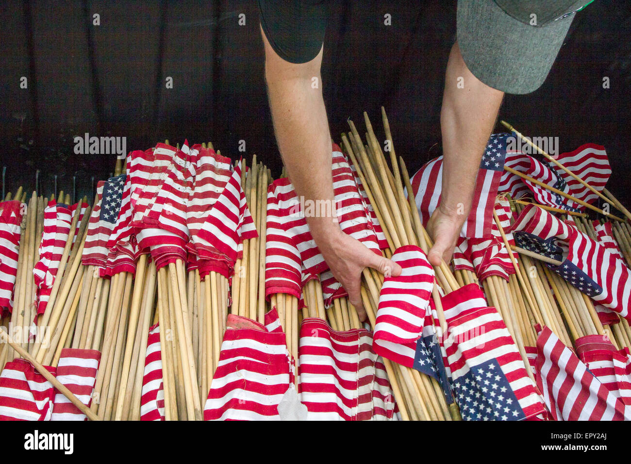 A volunteer gathers American flags to place at gravesites during ...