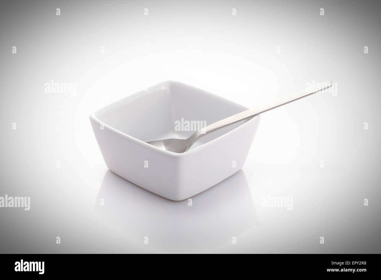 spoon in a square bowl isolated on a white background Stock Photo - Alamy