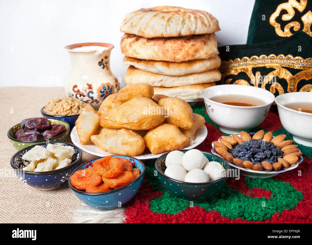 Kazakh national food on the table with national hat and tea at white ...