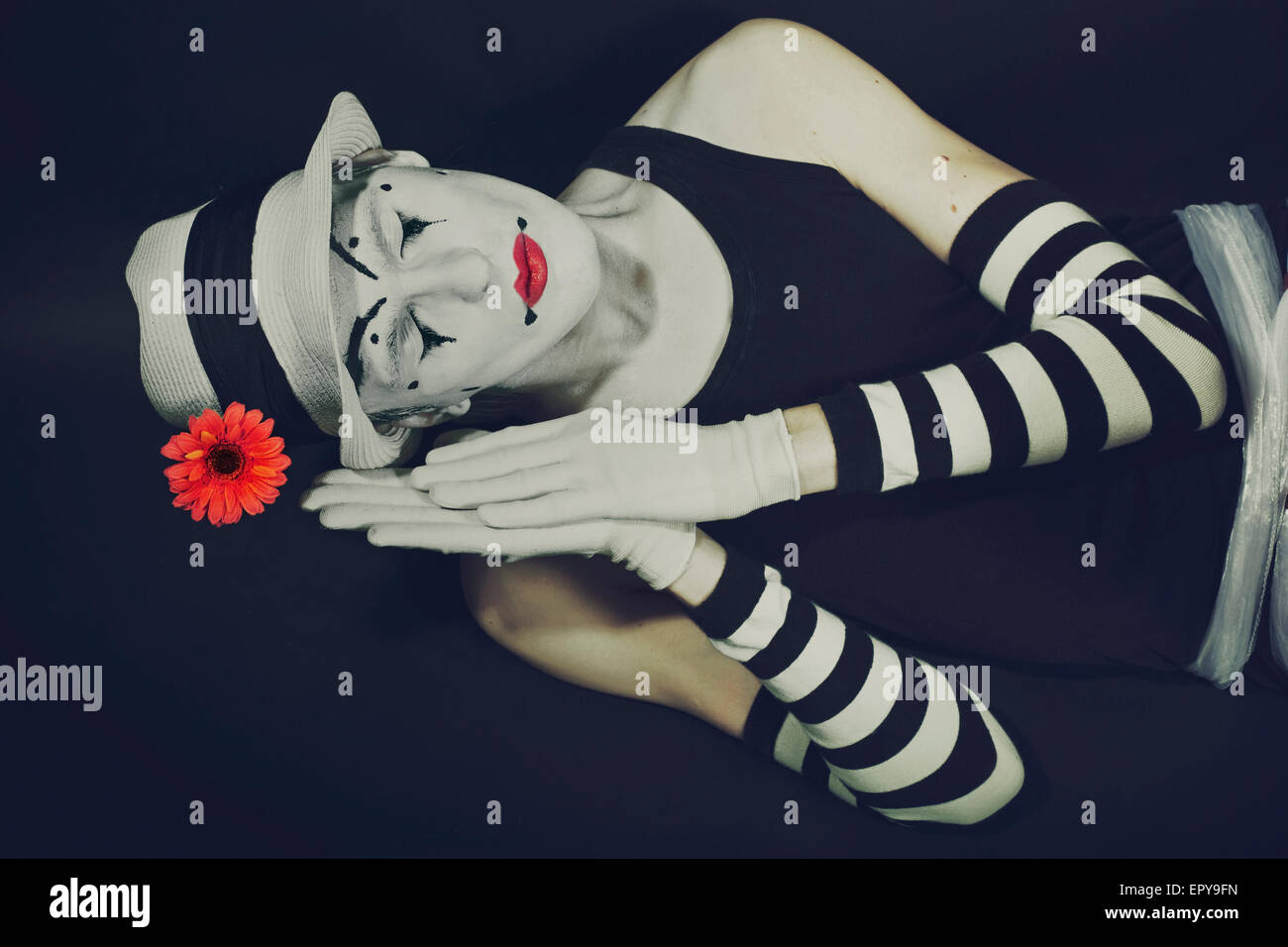 sleep mime in white hat with red flower on a black background Stock ...