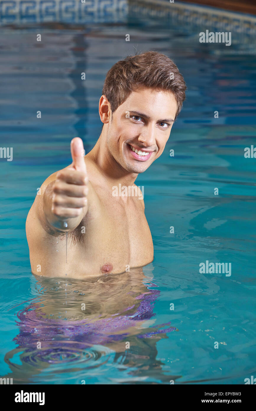 Smiling man in a swimming pool holding his thumbs up Stock Photo - Alamy