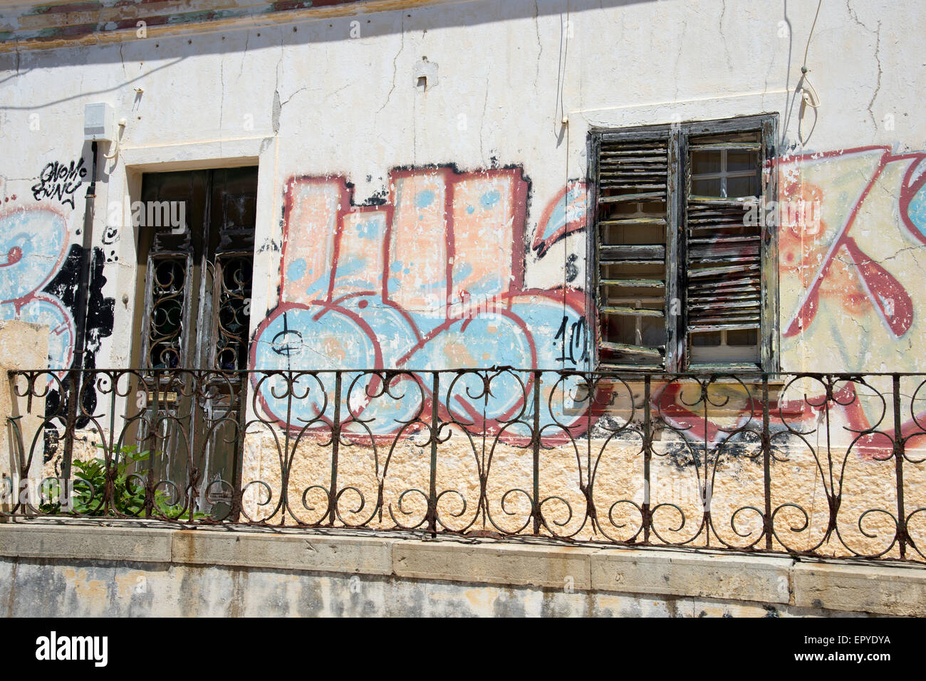 Graffiti painted around window shutters of a derelict house in the ...
