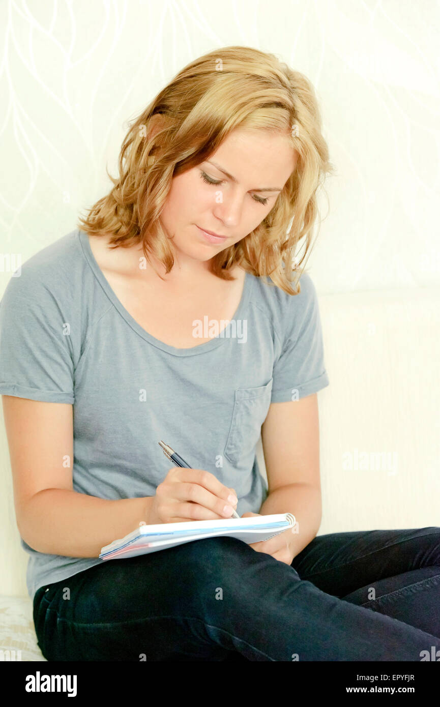 Young woman making notes in notebook Stock Photo - Alamy