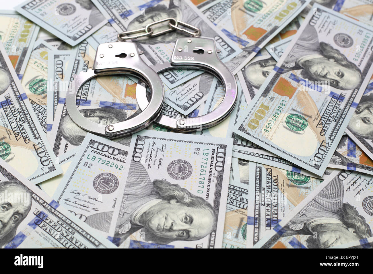 handcuffs on a pack of dollars Stock Photo - Alamy