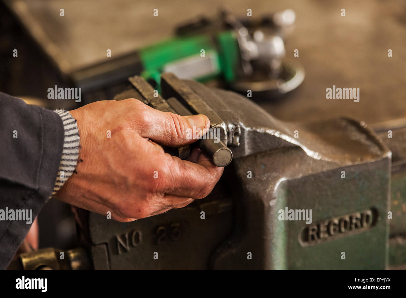Hand of a Man Putting Metal Rod in to A Vice Mounted on Workbench Stock ...