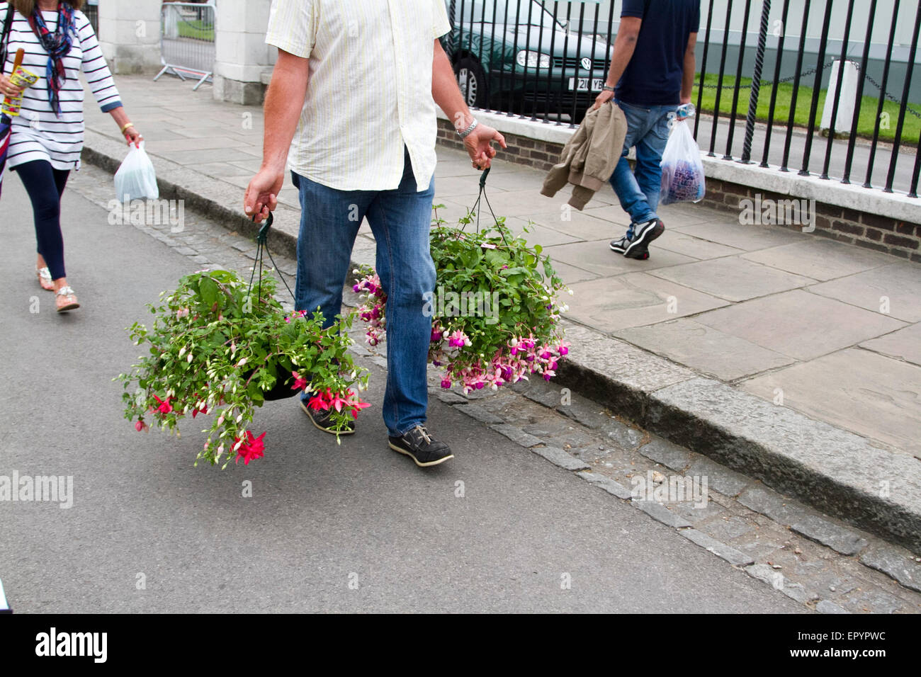 London UK. 23rd May 2015. Members of the public carry colorful flowers ...